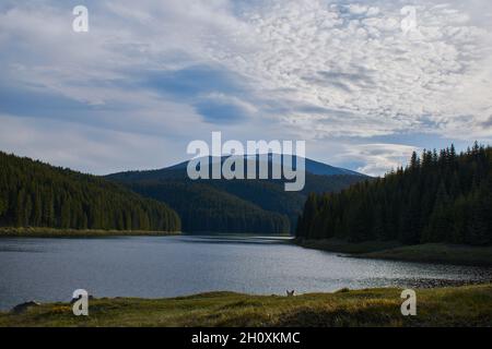 A view over the Lake Oasa in Mountains Sureanu with sky with clouds and ...
