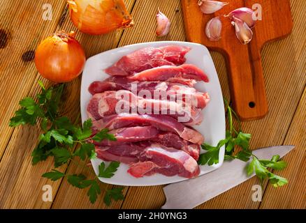 Raw fillet of farm Turkey thigh. Dark wooden background. Top view. Copy ...