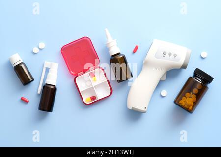 first aid kit, electronic thermometer and glasses on table in office ...