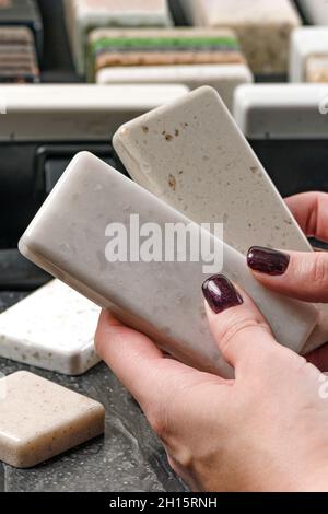 Choice of tiles. Female hands hold samples of tiles of different colors ...