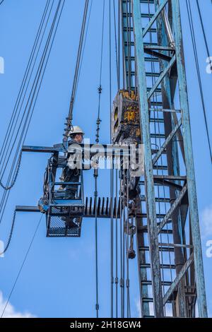 The derrickhand or derrickman working in the rod basket on the mast of ...