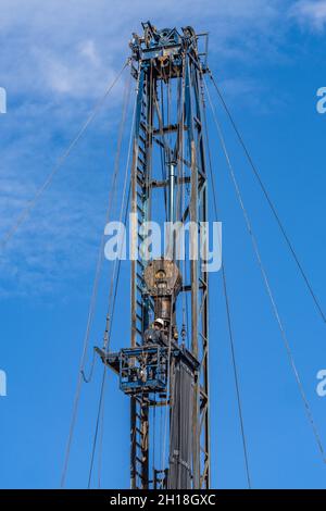 The derrickhand or derrickman working in the rod basket on the mast of ...