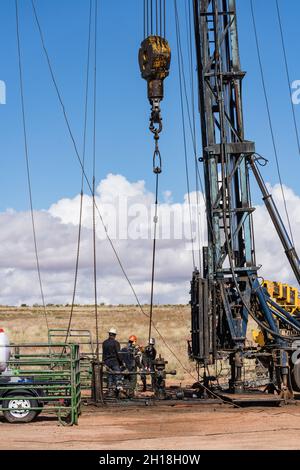 The well service crew on a workover rig works on an oil well to try to ...