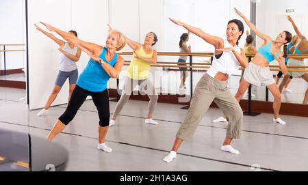 Women practicing vigorous dance movements in group dance class Stock ...