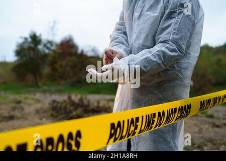 Concept of a crime scene with Forensic police picking up a gun isolated ...