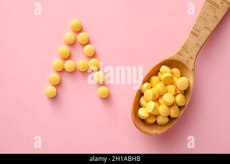 Letter A made of pills with spoon on pink background Stock Photo - Alamy