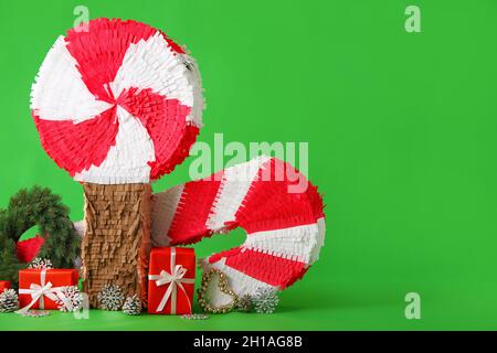 Mexican pinatas with gifts on green background with space for text ...