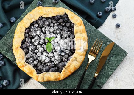 Board with tasty blueberry galette on light background Stock Photo - Alamy