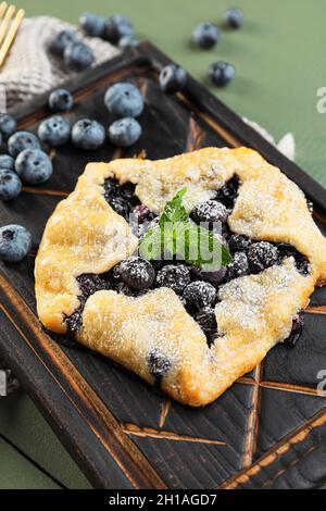 Board with tasty blueberry galette on light background Stock Photo - Alamy