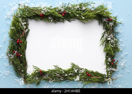 Composition with blank sheet of paper and coniferous branches on red ...
