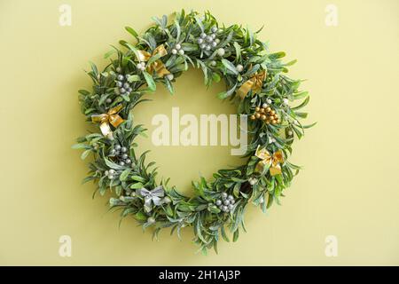 Beautiful mistletoe wreath on color wall Stock Photo - Alamy