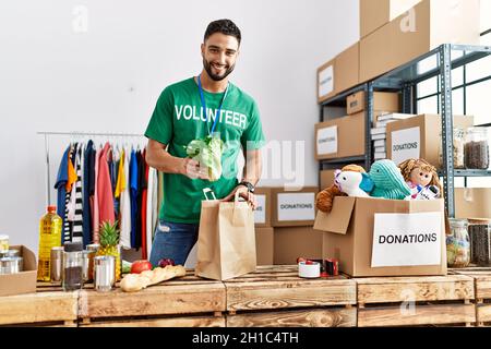 Young arab man wearing volunteer uniform talking on the smartphone ...