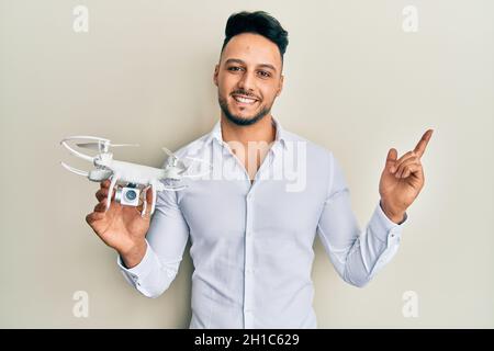 Arabian man with remote controller pointing with finger near popcorn ...
