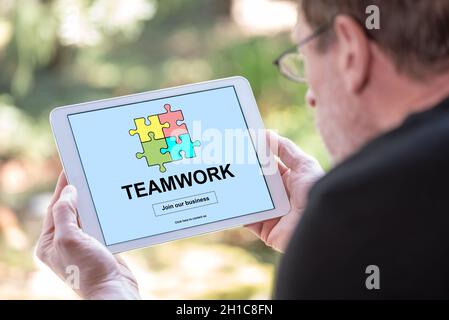 Tablet screen displaying a teamwork concept Stock Photo - Alamy