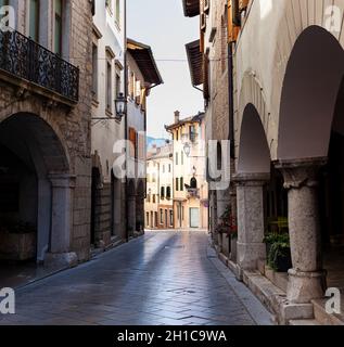 View of the Gemona Street with the typical arches of old town city ...