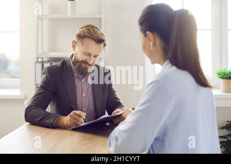 Woman client putting signature on legal document Stock Photo - Alamy