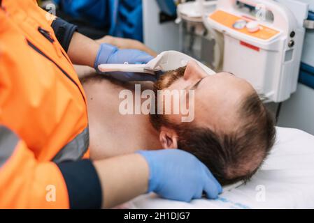 Paramedic putting a cervical collar to a patient in the ambulance Stock ...