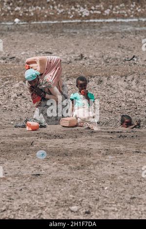 Villagers transport drinking water in plastic containers on their ...