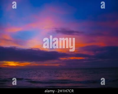 Image of the red sun setting over the ocean Stock Photo - Alamy