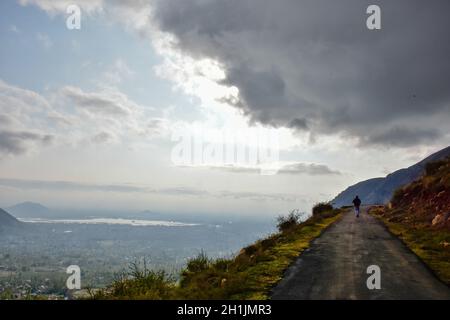 Srinagar, India. 18th Oct, 2021. A cyclist rides along the road during a cloudy day on the ...