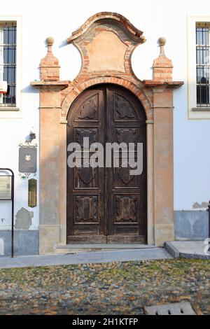 Imponent wooden door with a terracotta bricks arch Stock Photo - Alamy