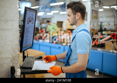 Bicycle factory, worker manages bike assembly line Stock Photo - Alamy