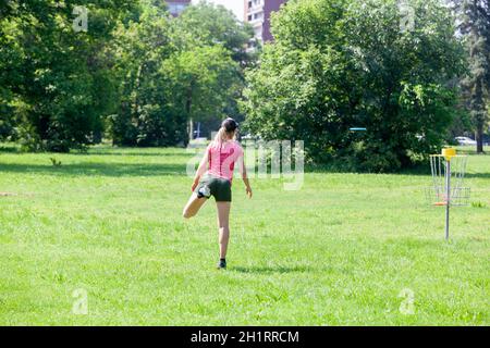 Disc golf player throwing a flying disc in the park Stock Photo - Alamy
