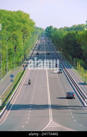 Panorama of motorway with cars and green trees on sides of road. High ...
