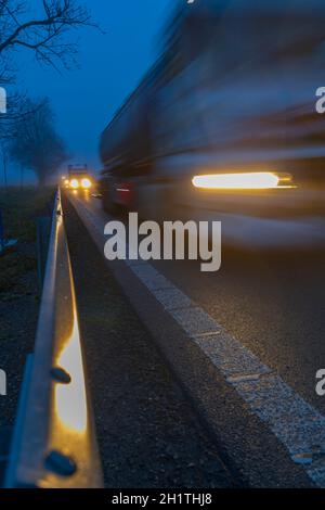 Lighted cars at dusk on main road Stock Photo - Alamy