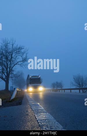 Lighted cars at dusk on main road Stock Photo - Alamy