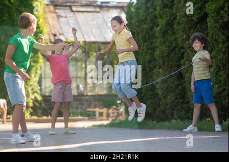 Group of friends playing jump rope Stock Photo - Alamy