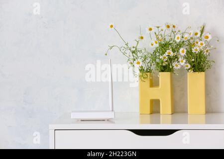 Wi-Fi router and flowers on yellow background Stock Photo - Alamy