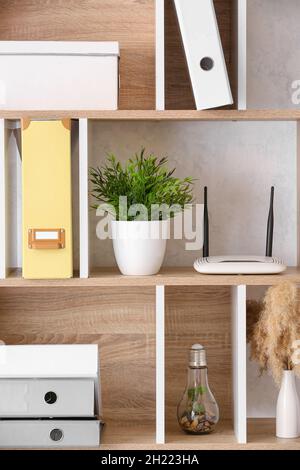 Modern wi-fi router and houseplant on wooden rack indoors Stock Photo ...