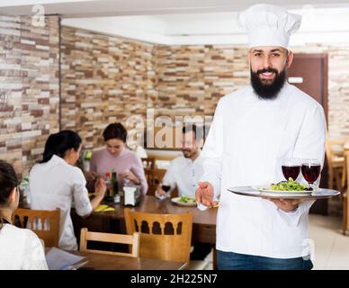 Chef taking care of adults at cafe table Stock Photo - Alamy