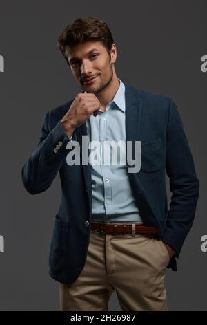 Sly handsome bearded young man in glasses and red beanie, smiling hideous having interesting ...