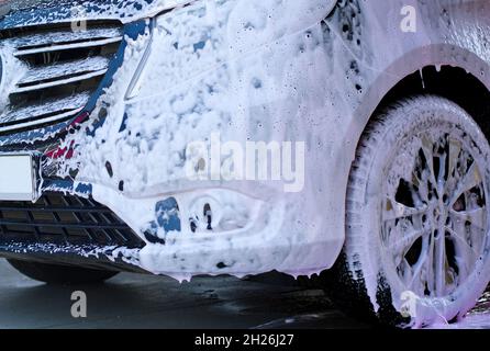 Car in foam. Car getting a wash with soap, car washing Stock Photo - Alamy