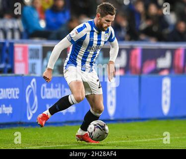 Oliver Turton #20 of Huddersfield Town holds. The ball as Olamide ...