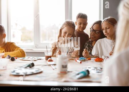 Smiling classmates making art painting using water colors Stock Photo ...