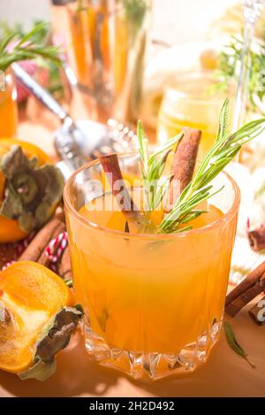 Autumn alcohol drinks. Spicy boozy gin persimmon cocktail with rosemary ...