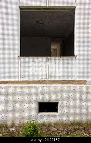 Broken tenement building exterior of an apartment house. Plaster is ...