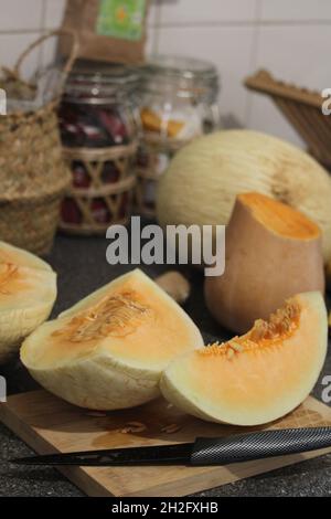 Kitchen table with cut and whole melons Stock Photo - Alamy