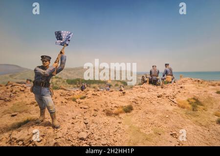 Sargeant John Quick uses a flag to signal a Navy gunship during the ...
