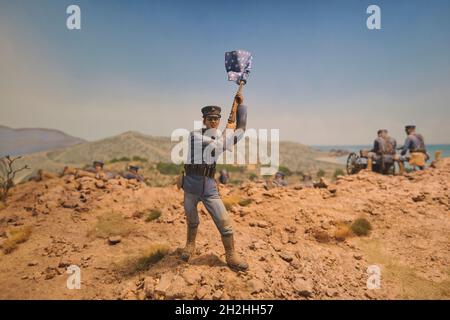Sargeant John Quick uses a flag to signal a Navy gunship during the ...