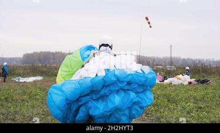 Man carries parachute. Action. Man carries multi-colored parachute ...