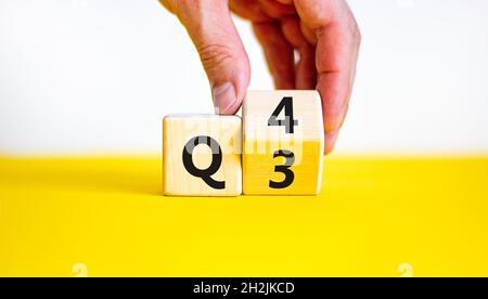 From 3rd to 4th quarter symbol. Businessman turns a wooden cube and ...