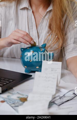 Happy Woman With Bills Putting Coin In Piggybank At Desk Stock Photo ...