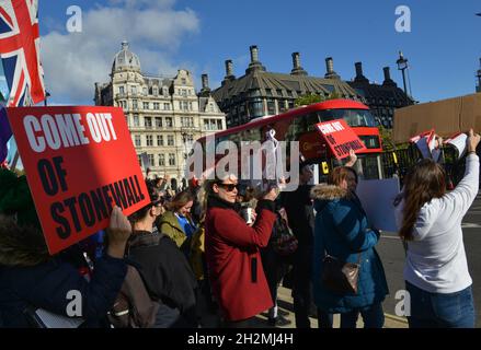 Protesters hold placards at a demonstration calling for an end to ...