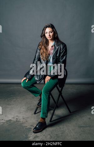 Woman in Leather Jacket Sitting on Motorcycle. Confident woman seated ...