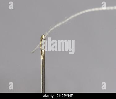 Macro shot of a thread passing through a needle Stock Photo - Alamy