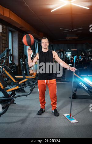 attractive male athlete cleaner have fun and dance and make cleaning in ...
